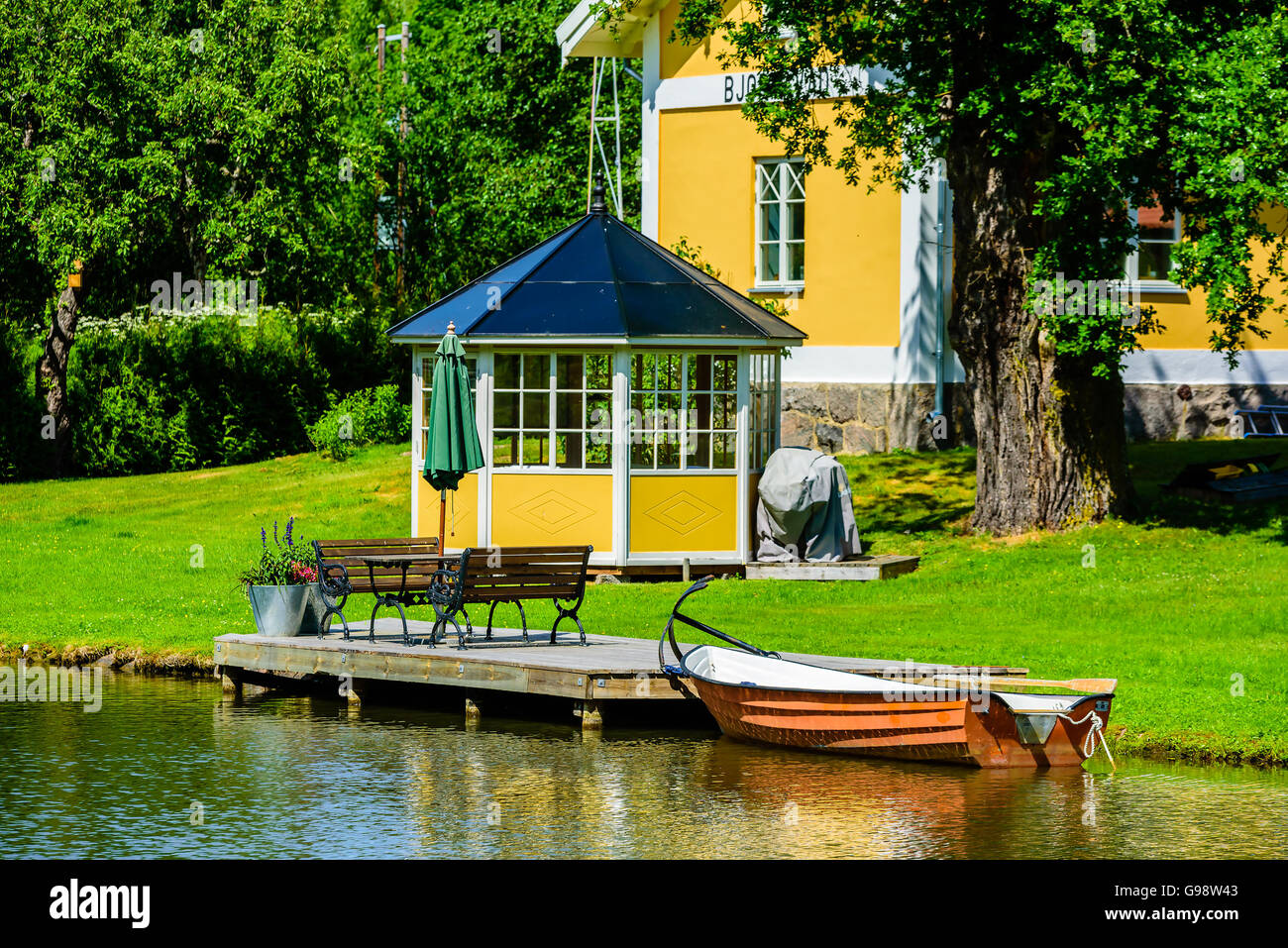 Bjornavad, Sweden – June 20, 2016: Small orange rowboat moored beside a ...