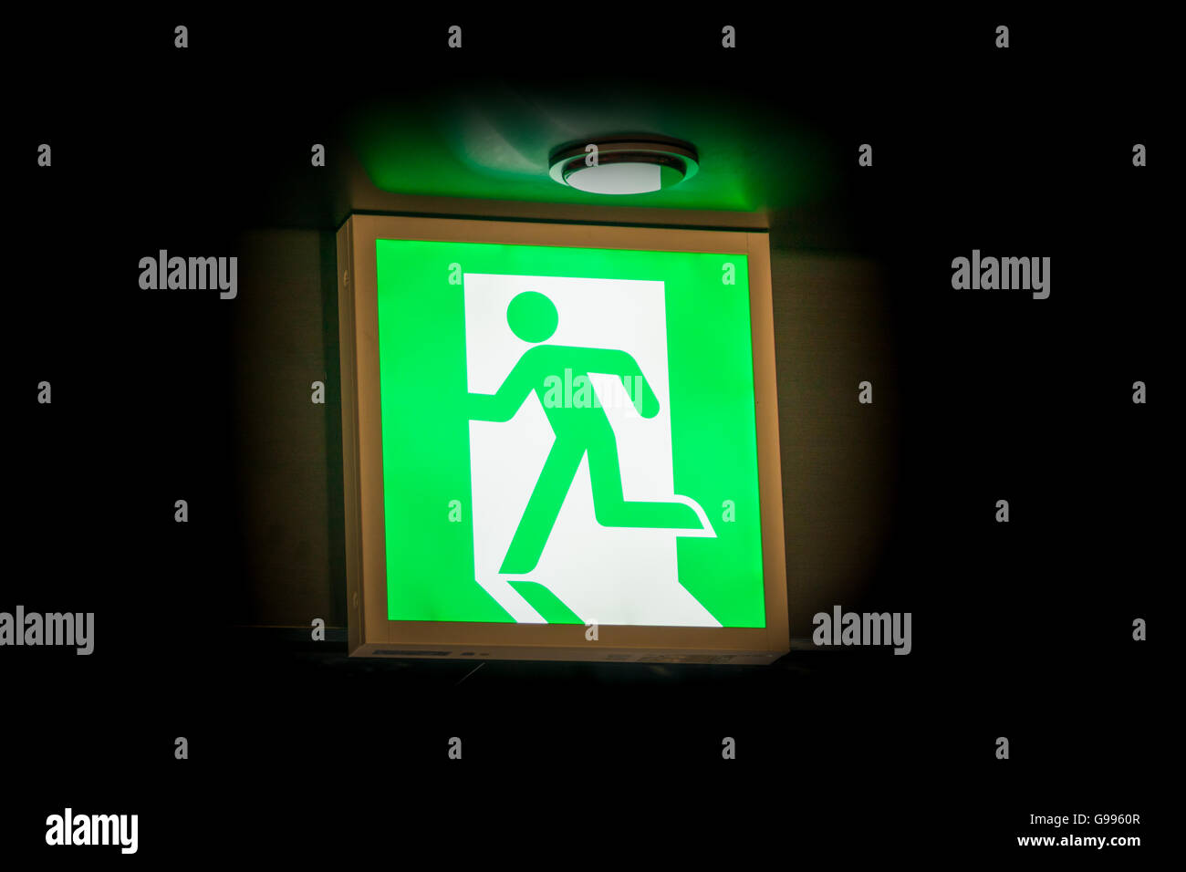 Emergency exit symbol glowing green in the blacked out background Stock ...