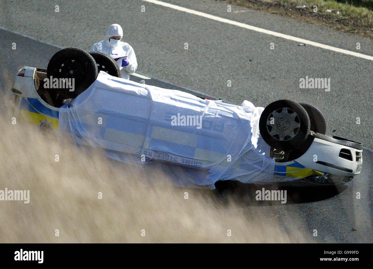 A forensic expert examines the police car which crashed on the A69 near ...