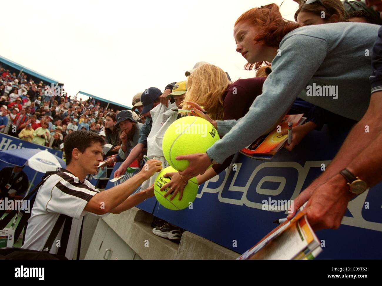 Tim Henman signs autographs for his fans after his third round victory ...