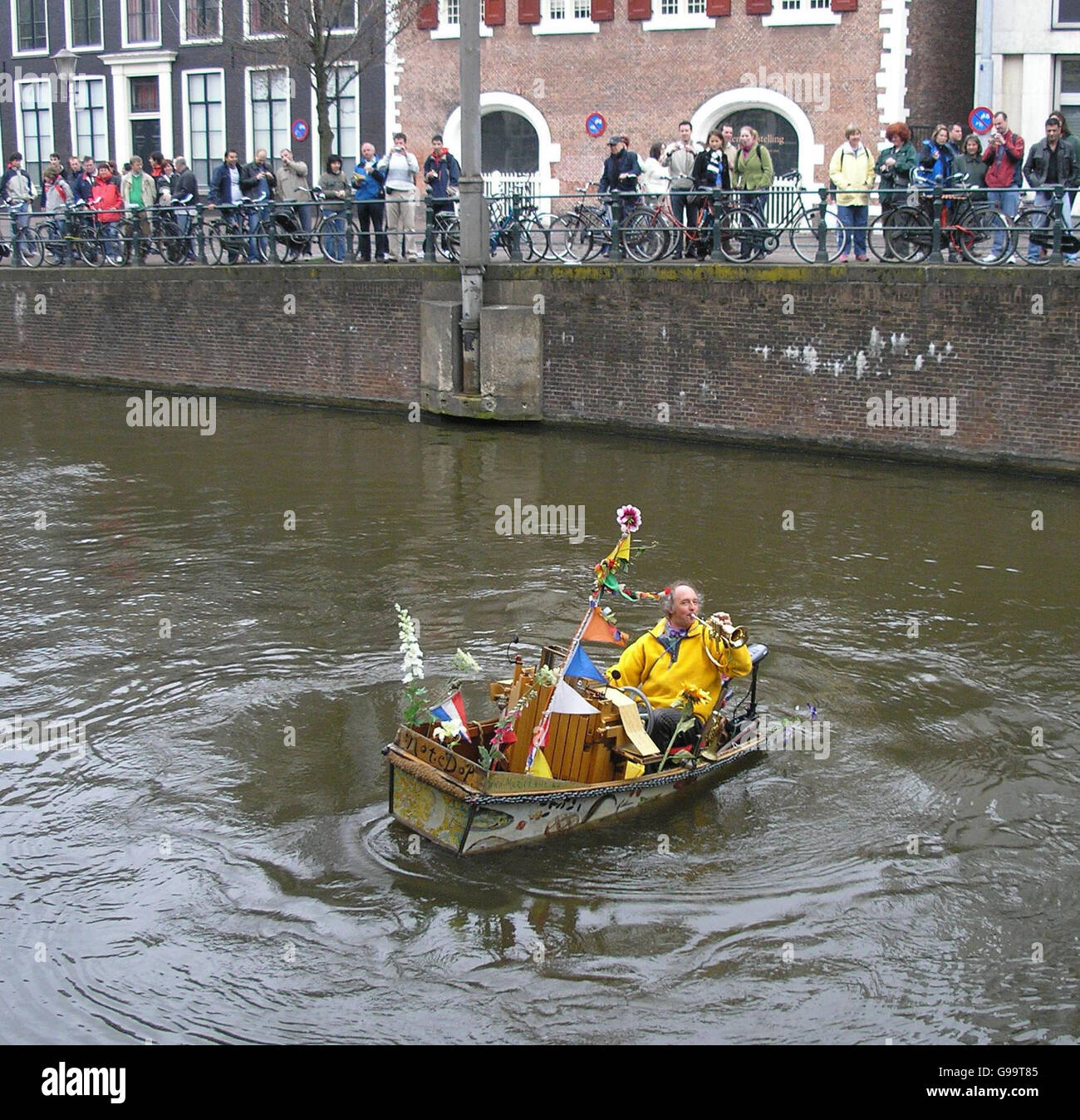 A busker floating on a canal entertains visitors to Amsterdam Stock ...