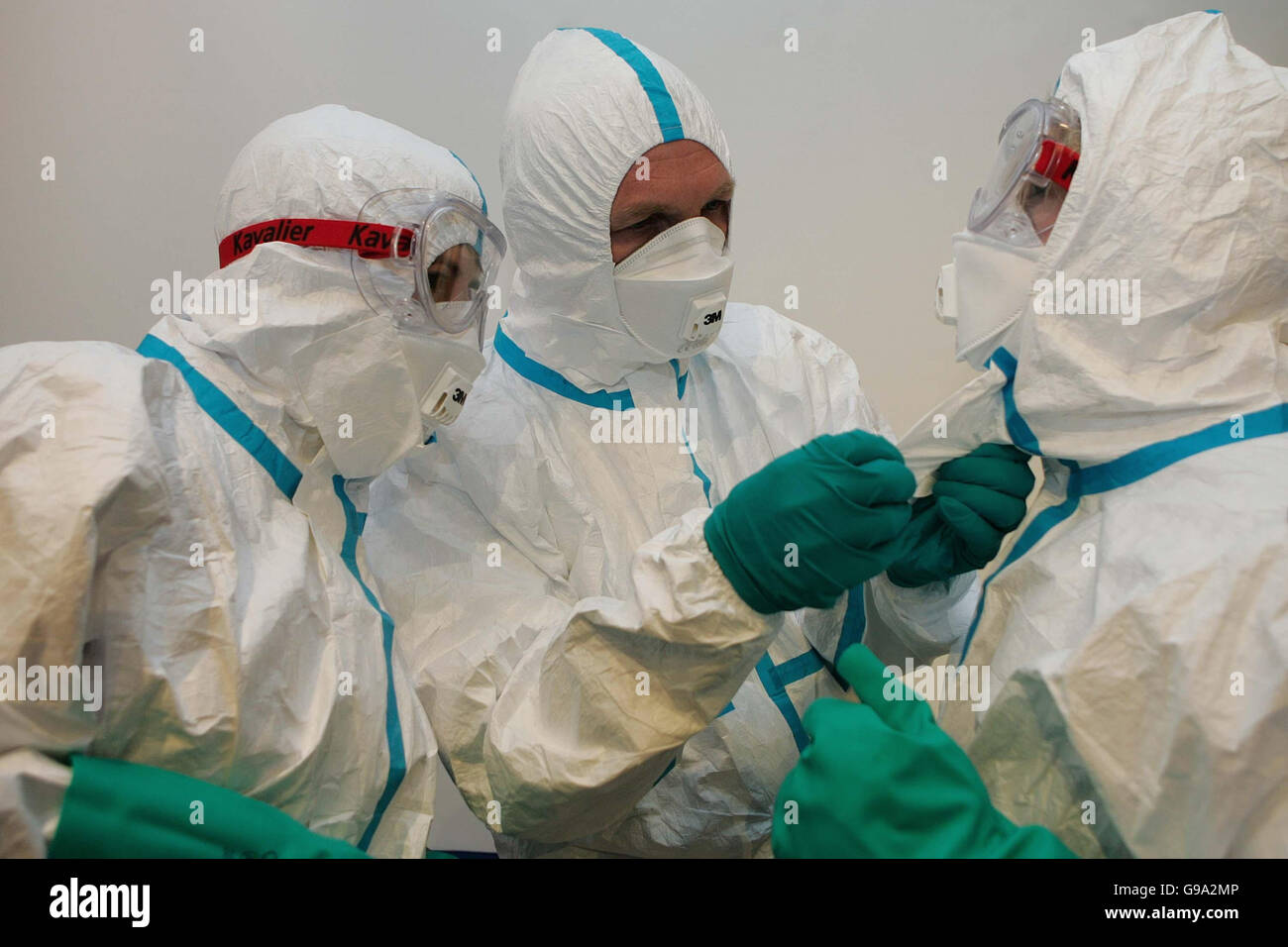 Journalists try on the latest biohazard protection suits during a press ...