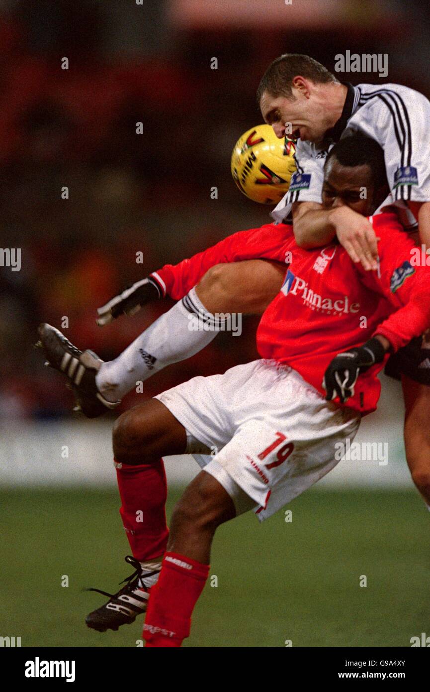 L-R; Nottingham Forest's Stern John is challenged for posession of the ...