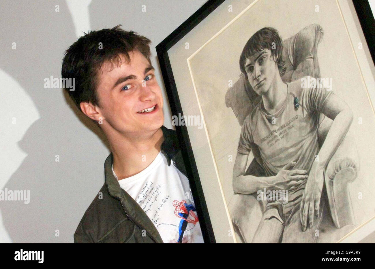Harry Potter star Daniel Radcliffe stands next to his portrait at the ...
