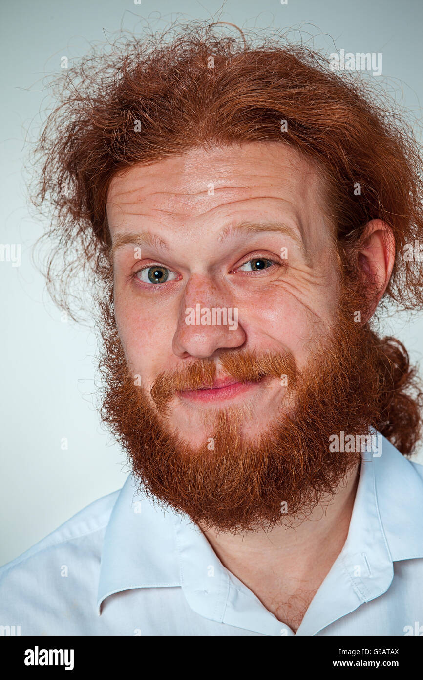 The young smiling man with long red hair looking at camera Stock Photo ...