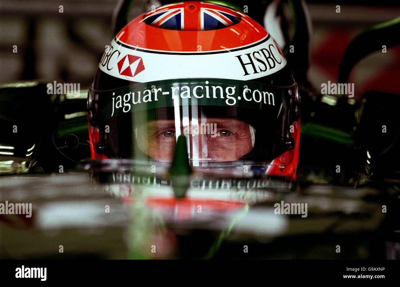 Johnny herbert waits in the jaguar garage during practice hi-res stock ...