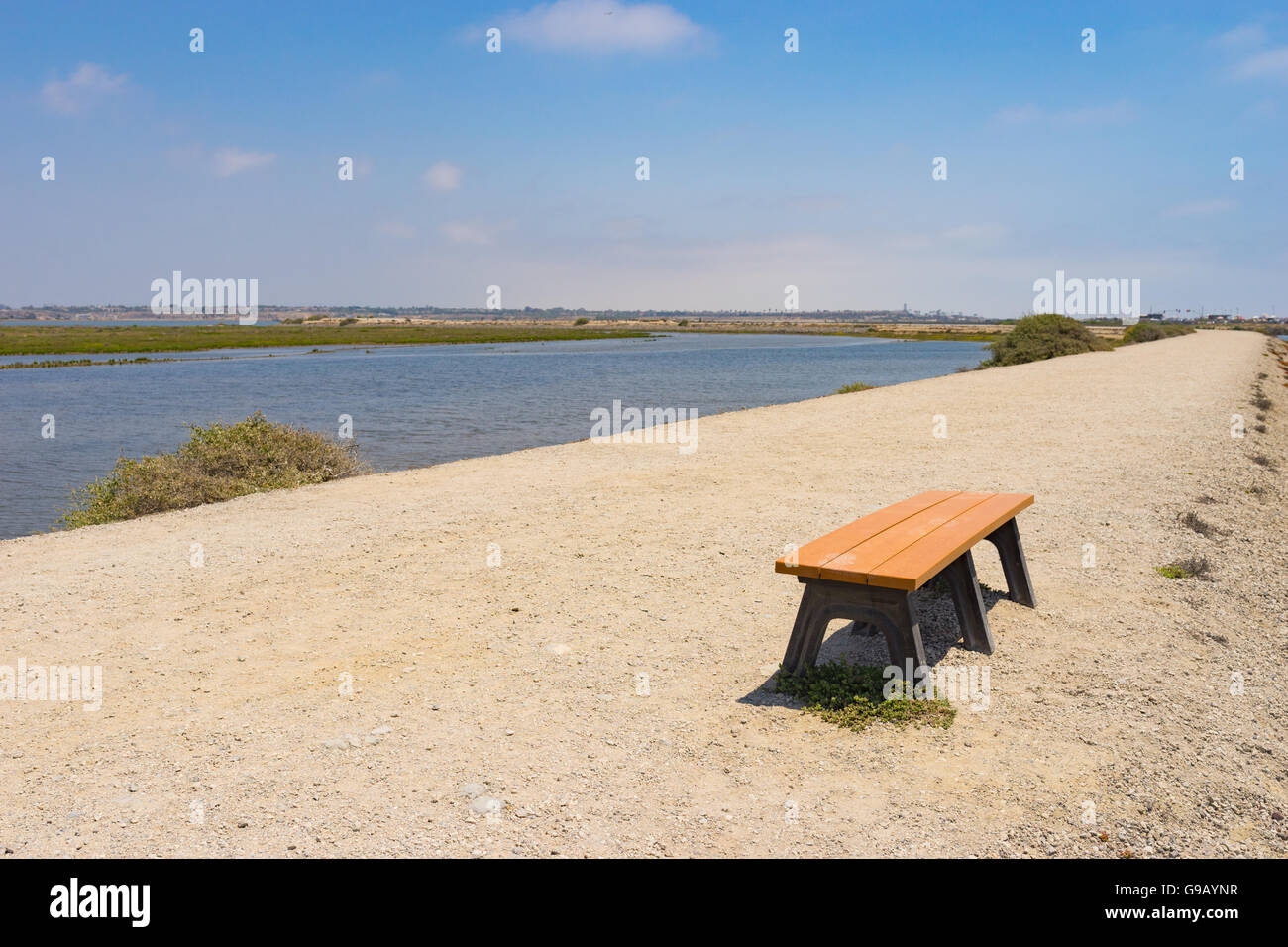 Wooden bench on sandy park trail near waterway Stock Photo - Alamy