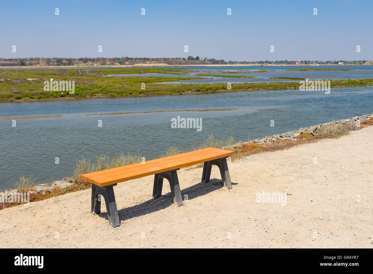 Wood bench on water edge and sandy park trail Stock Photo - Alamy
