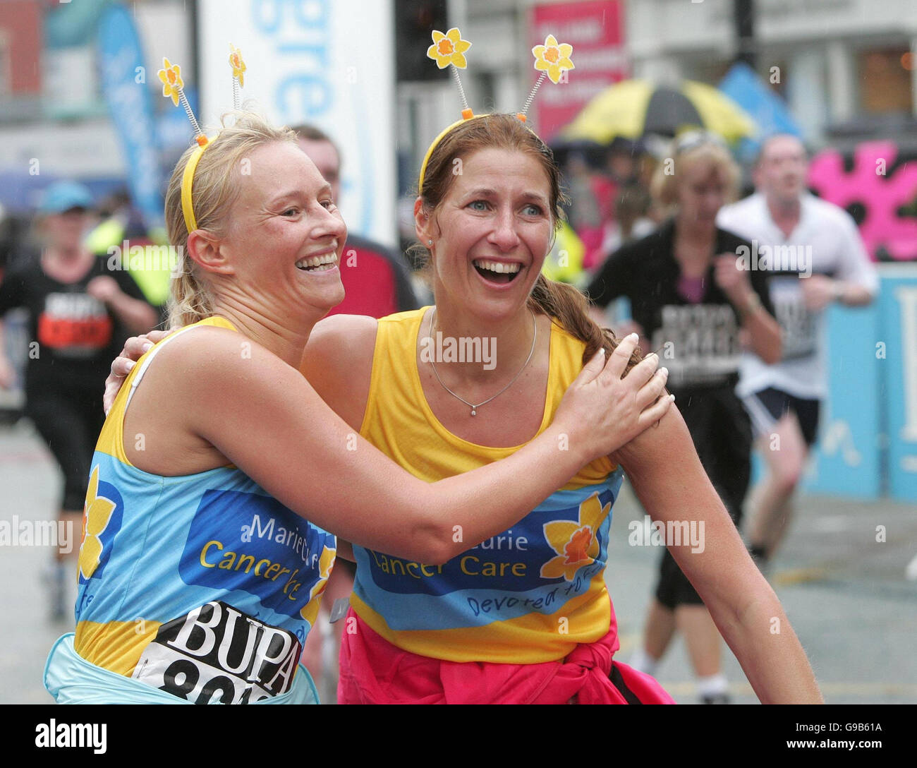 Runners celebrate as they finish the BUPA Great Manchester run Stock ...