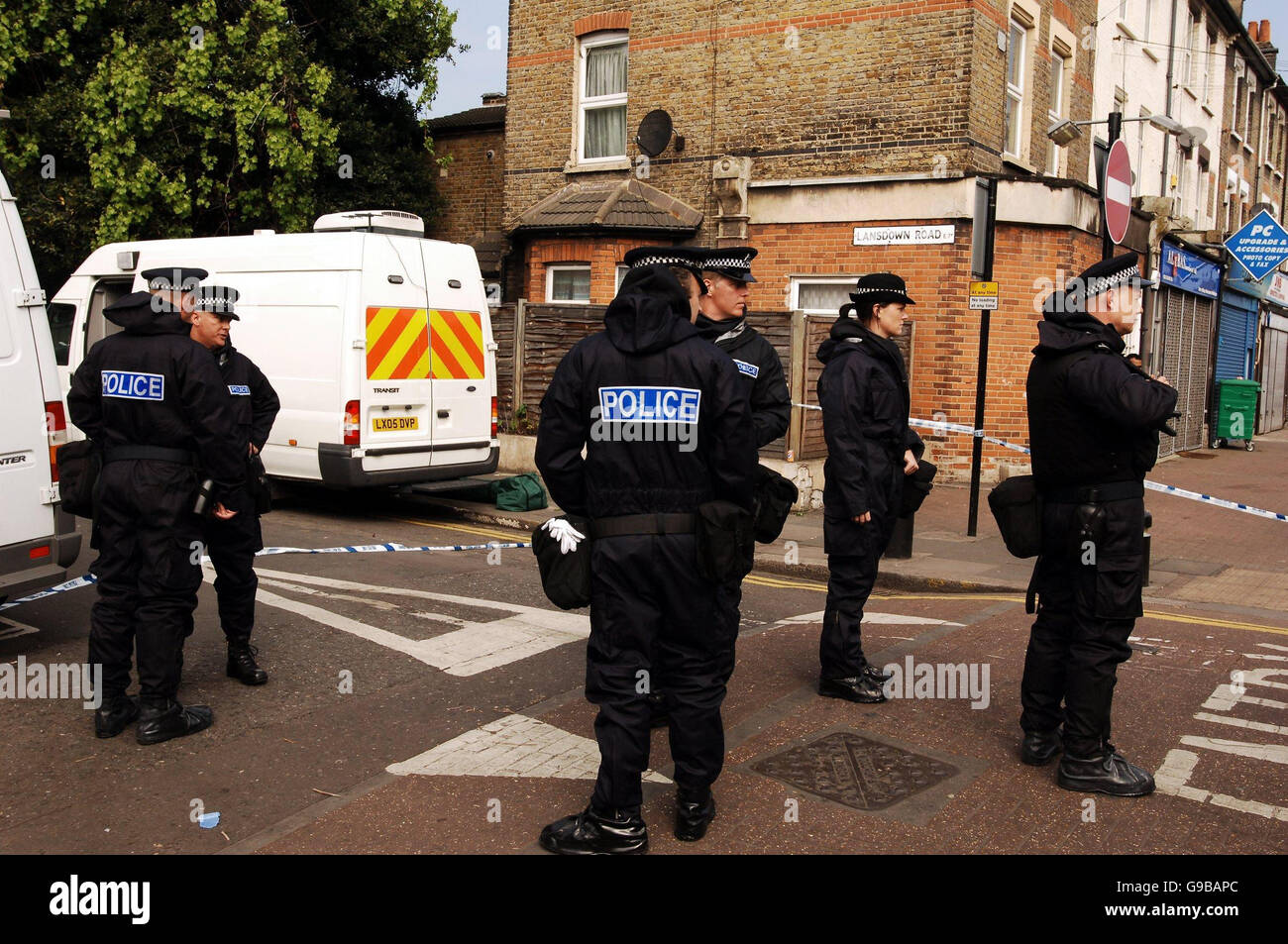 Police officers man a cordon after an early morning anti-terrorist raid ...