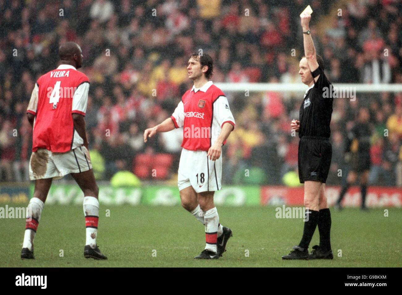 Referee Rob Harris (r) shows the yellow card to Arsenal's Patrick ...