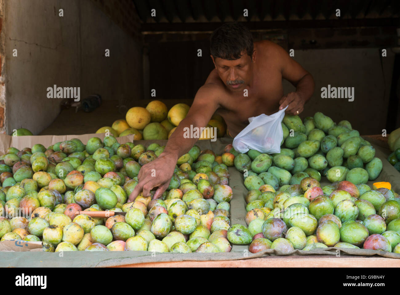 Man selling mangos on the street Stock Photo - Alamy