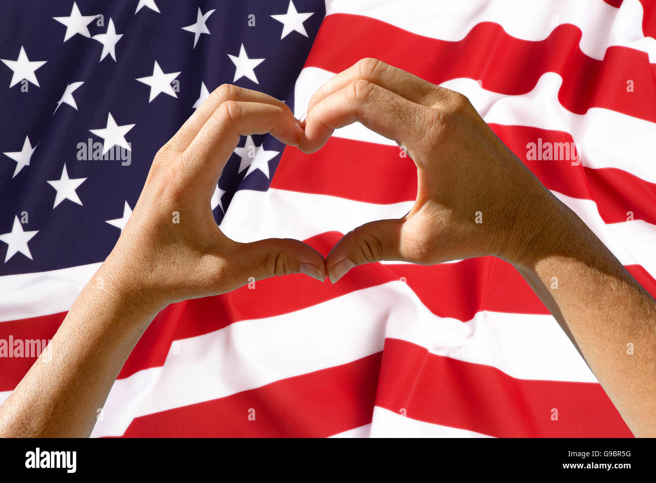 Female hands heart symbol with USA flag in background Stock Photo - Alamy