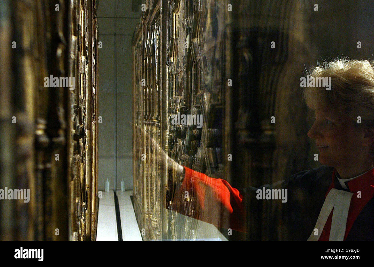Canon Jane Hedges walks past the The Westminster Retable, (a large ...