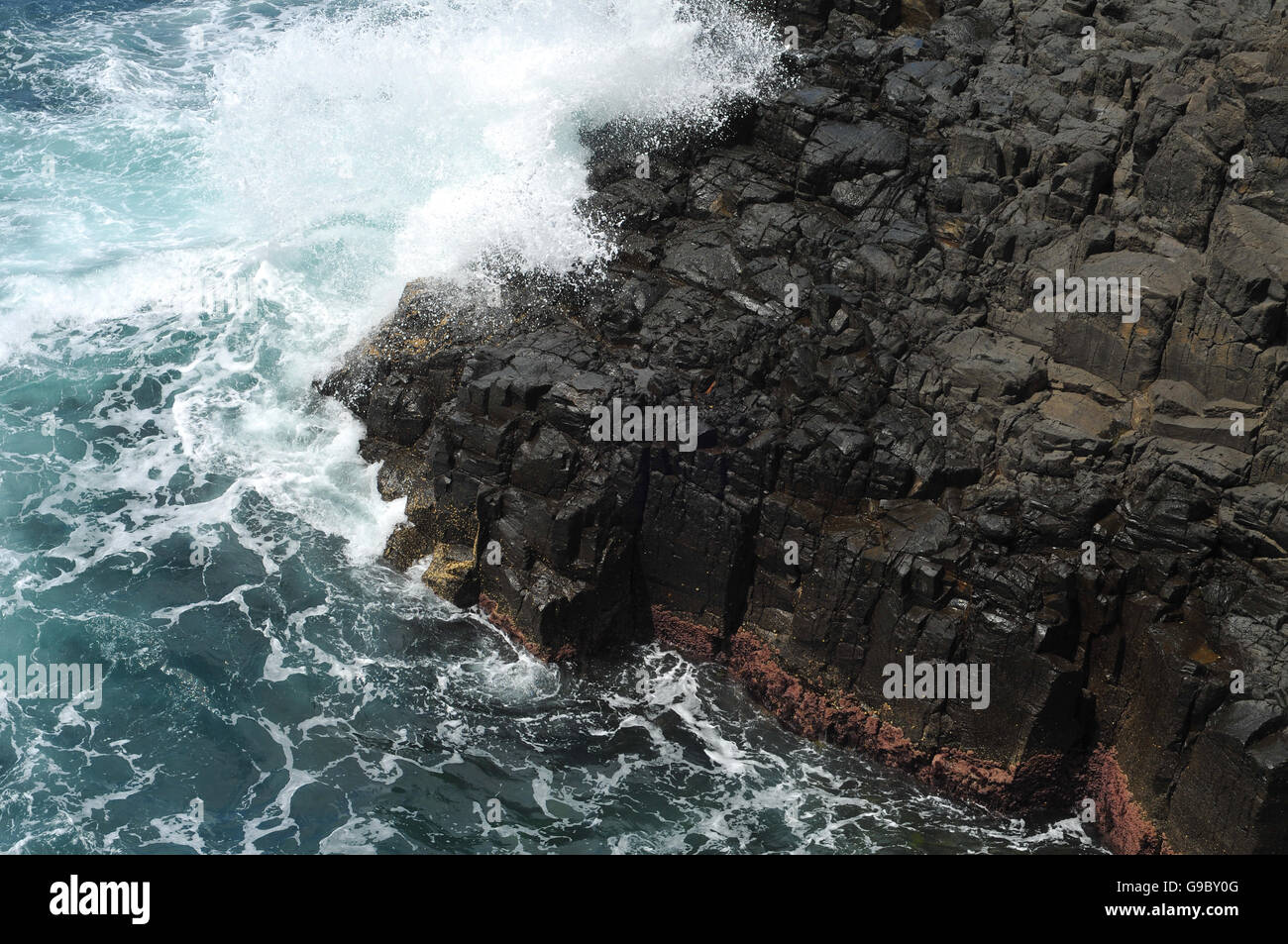 Waves crashing on volcanic cliffs Stock Photo - Alamy