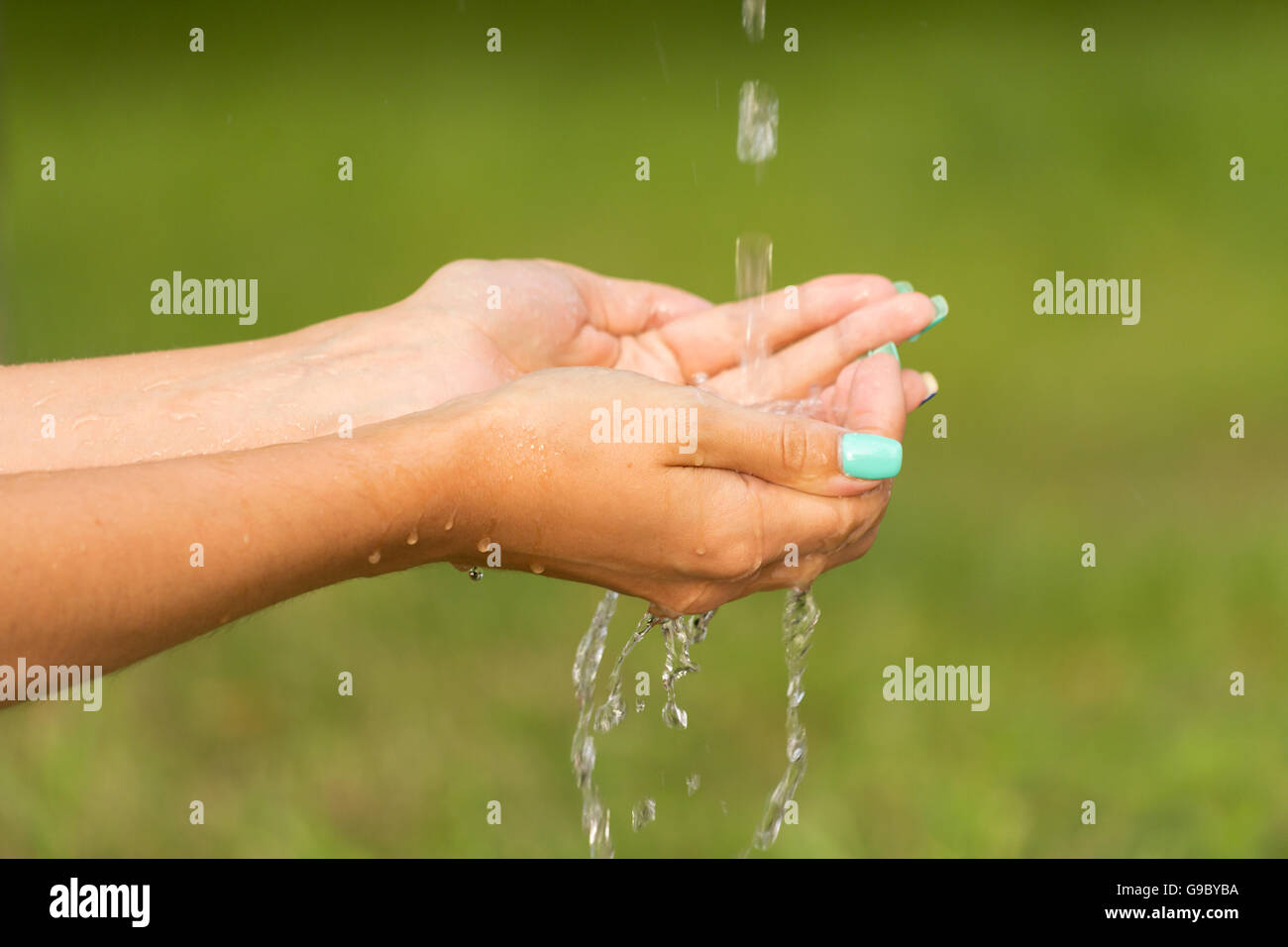 A stream water pouring on hands girl Stock Photo - Alamy