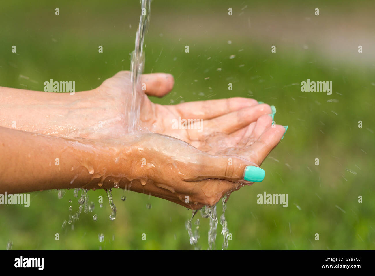 A stream water pouring on hands girl Stock Photo - Alamy