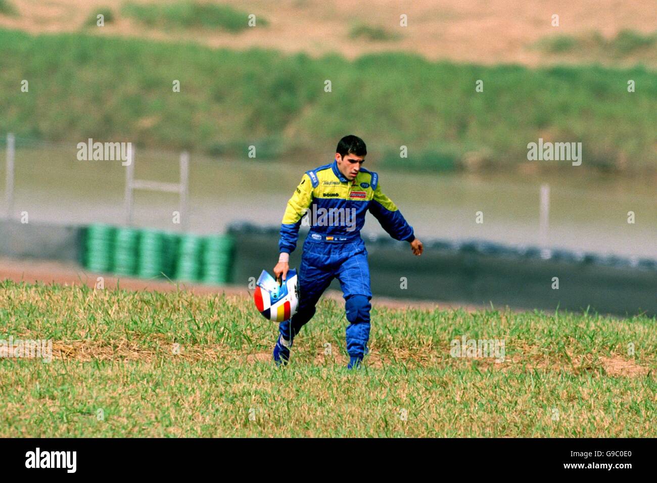 Marc Gene trudges back to the Minardi garage after retiring Stock Photo ...