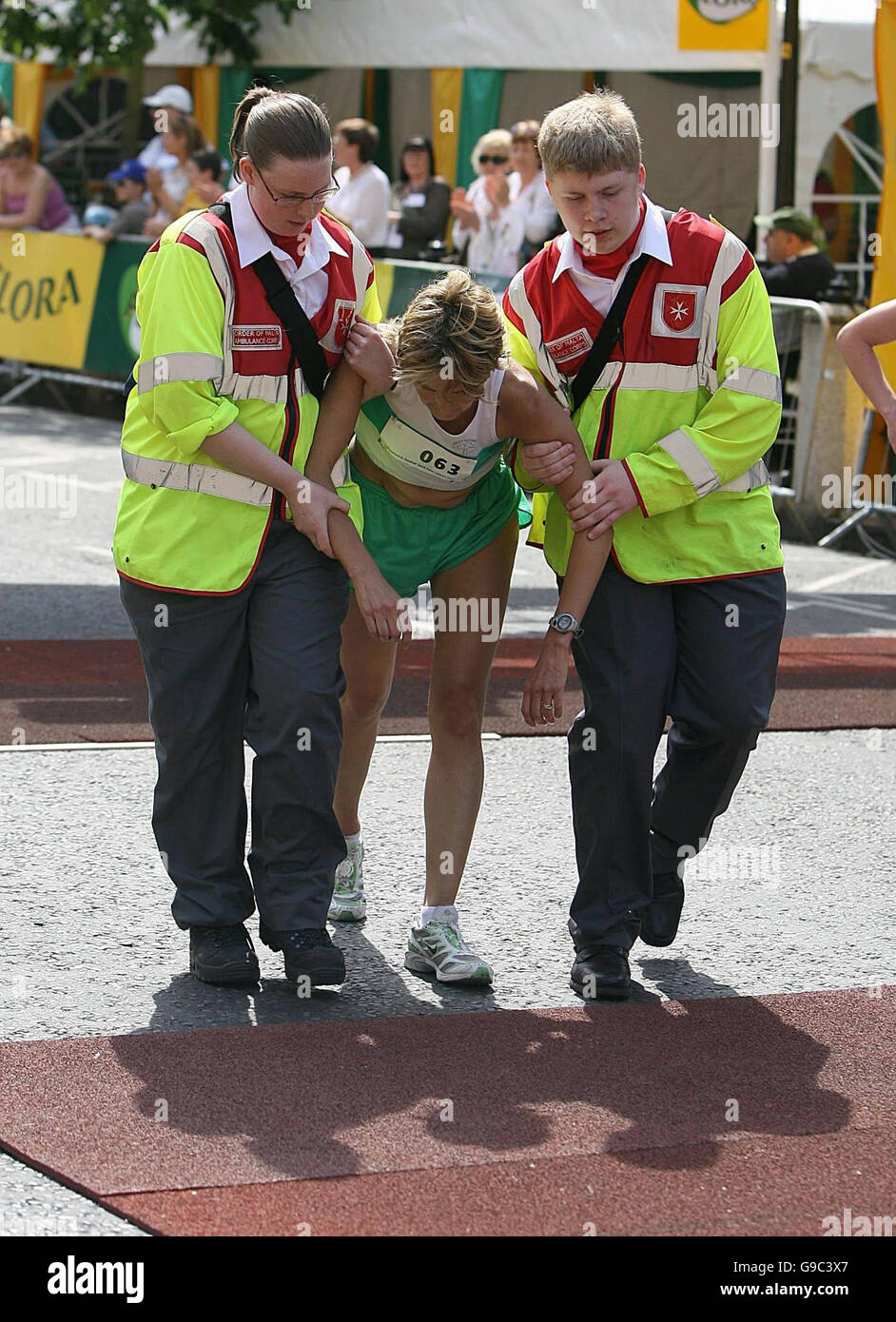 A competitor is help across the finish line during the Flora Women's ...