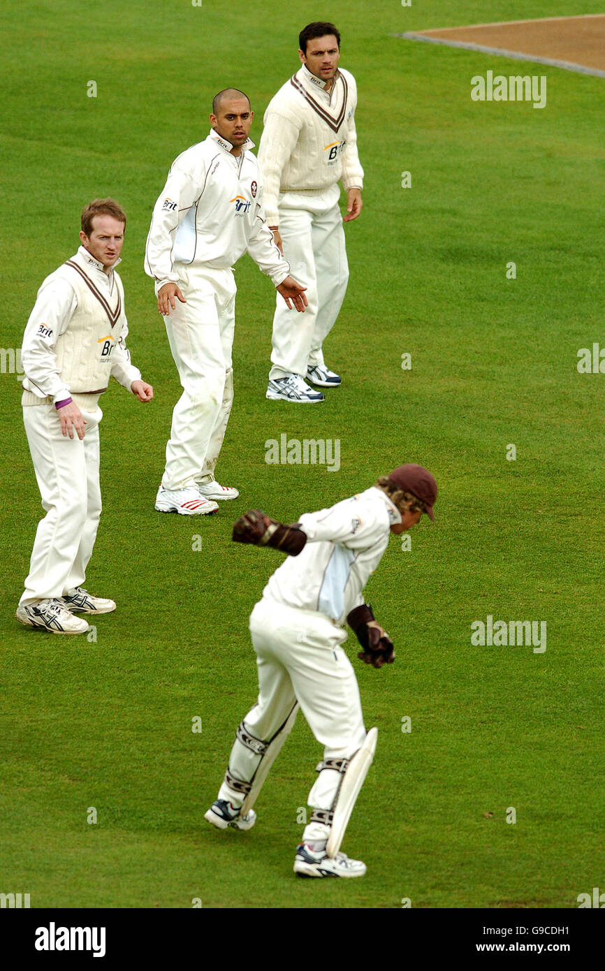 Bottom - Top: Surrey wicketkeeper Jonathan Batty drops a catch watched ...