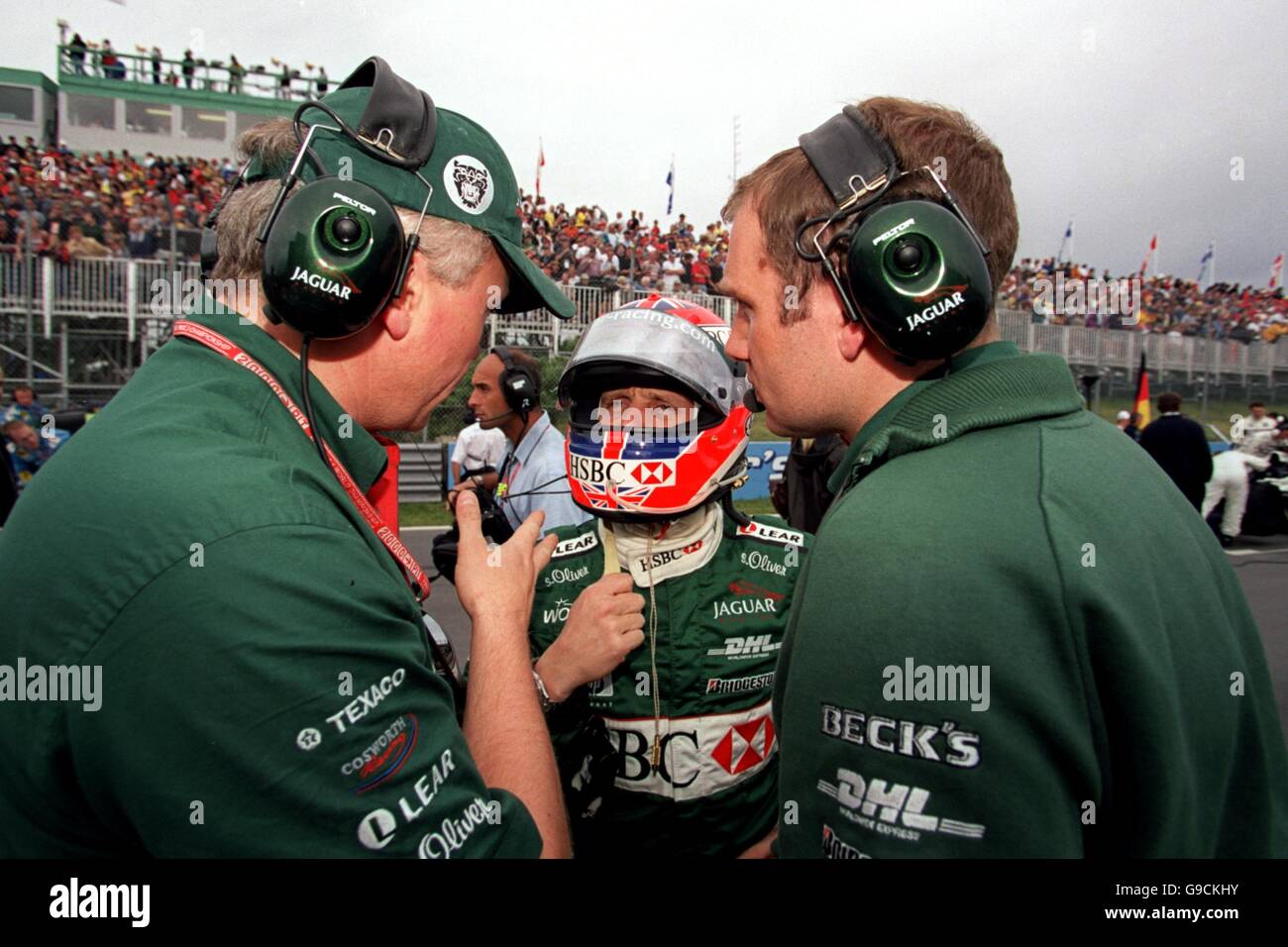 Jaguar driver Johnny Herbert (c) talks to two members of the British ...