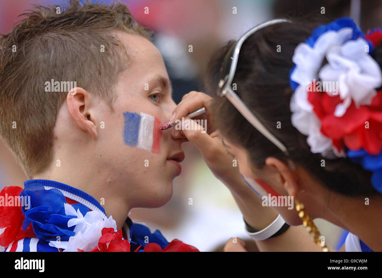 France fans paint each other faces in the style of their national flag ...