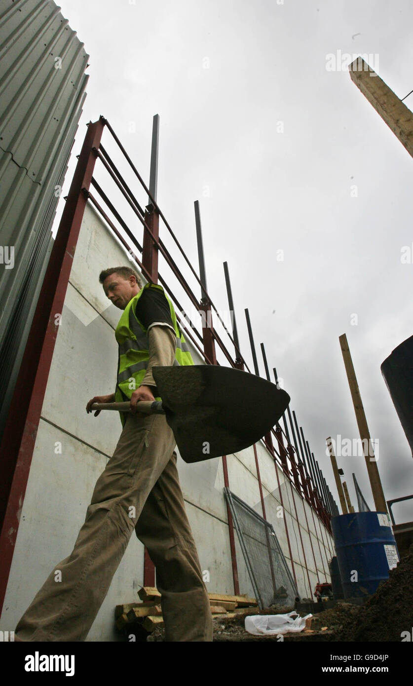 A workman builds a new section of Belfast's peace wall between ...
