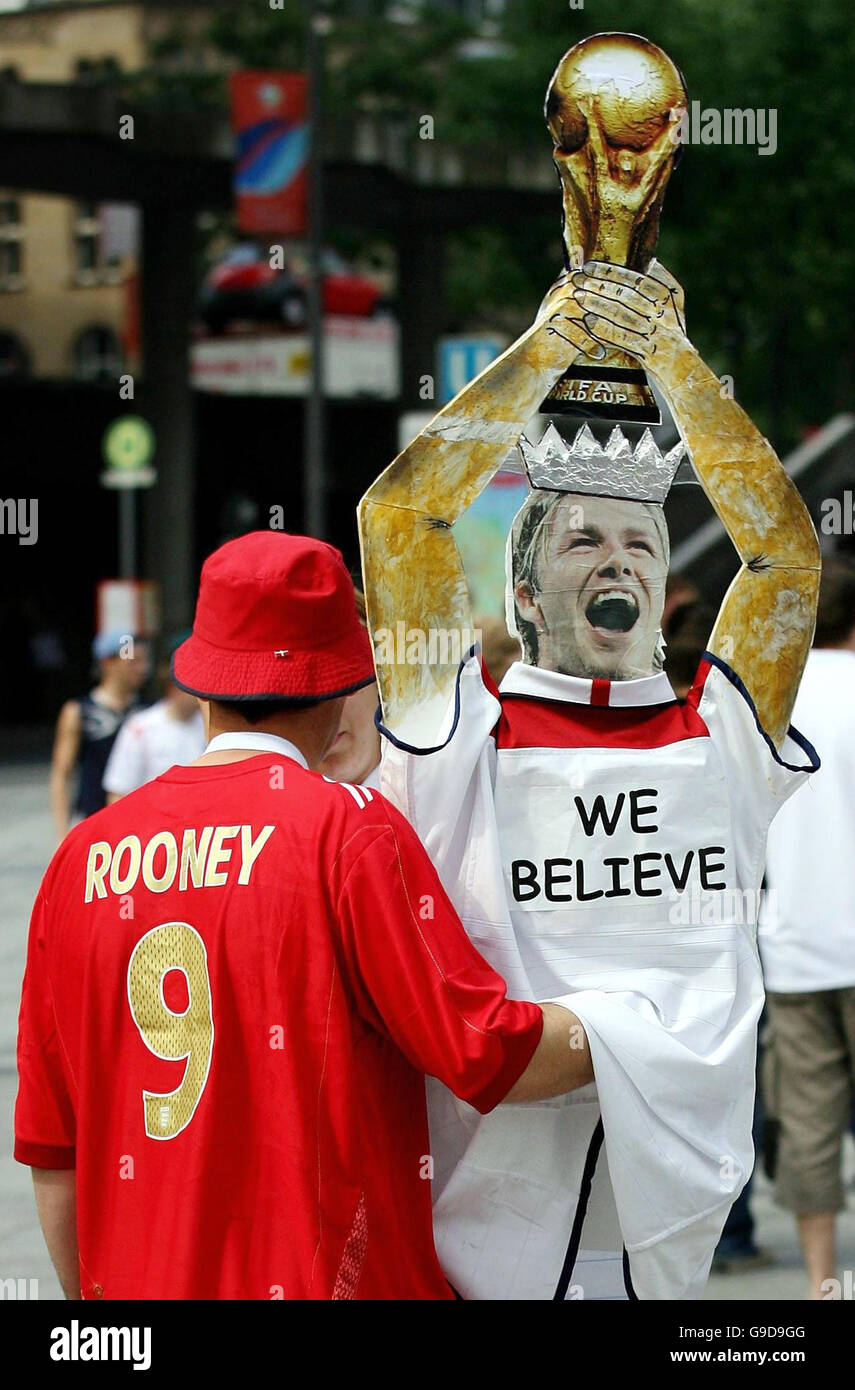 An England fan, with a cardboard cutout of David Beckham holding up the ...