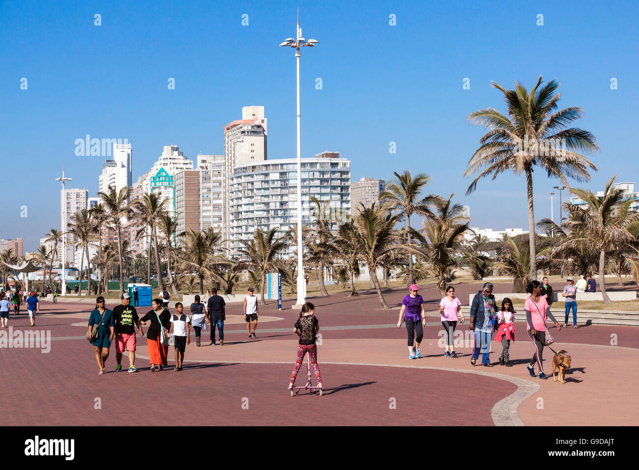 People on paved promenade on beach front against city skyline Stock ...