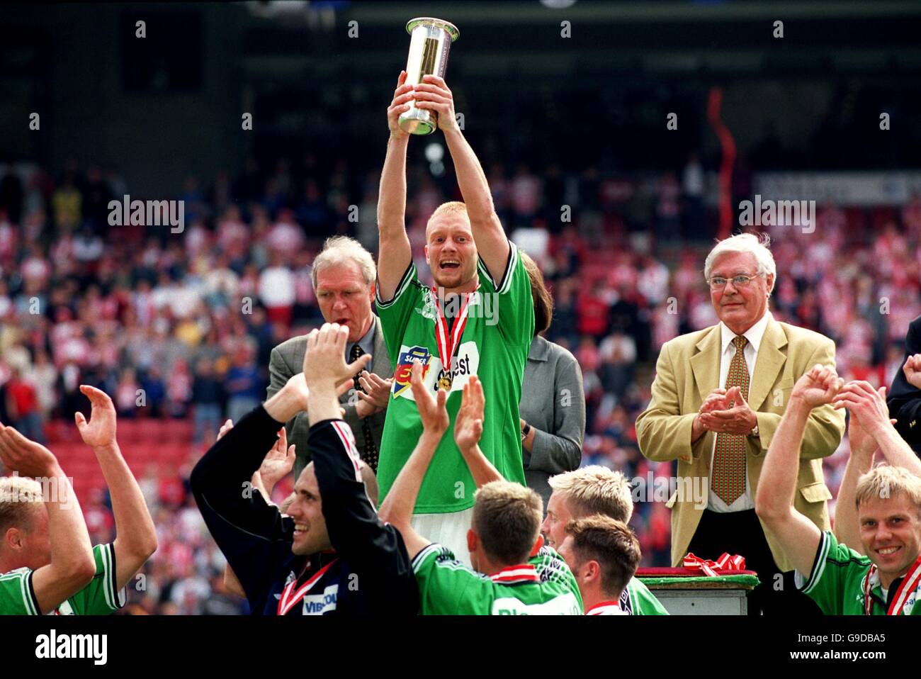 Holds aloft dong cup teammates celebrate around him hi-res stock ...