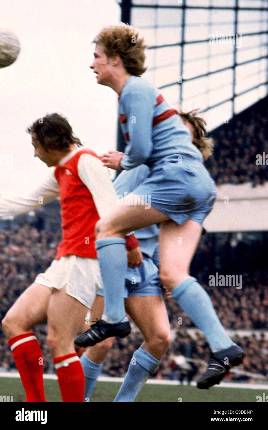 West Ham United's Kevin Lock (r) heads clear from Arsenal's John ...