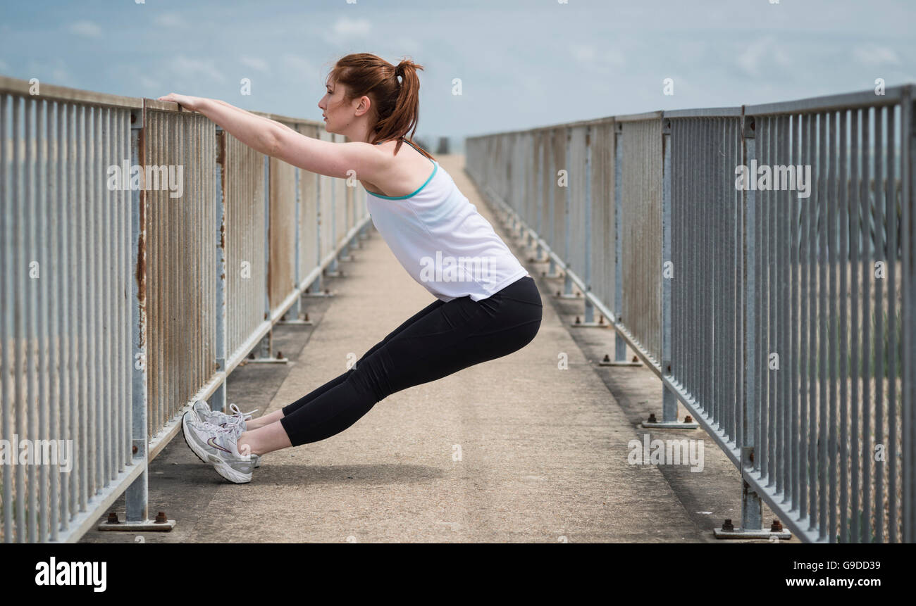 woman using metal railings as gym to exercise outside Stock Photo - Alamy