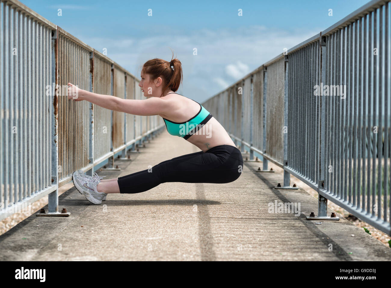 woman using metal railings as gym to exercise outside Stock Photo - Alamy