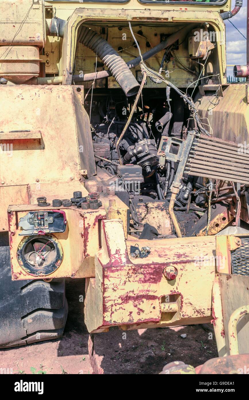 Broken and salvaged large yellow industrial machine at a scrap breakers ...