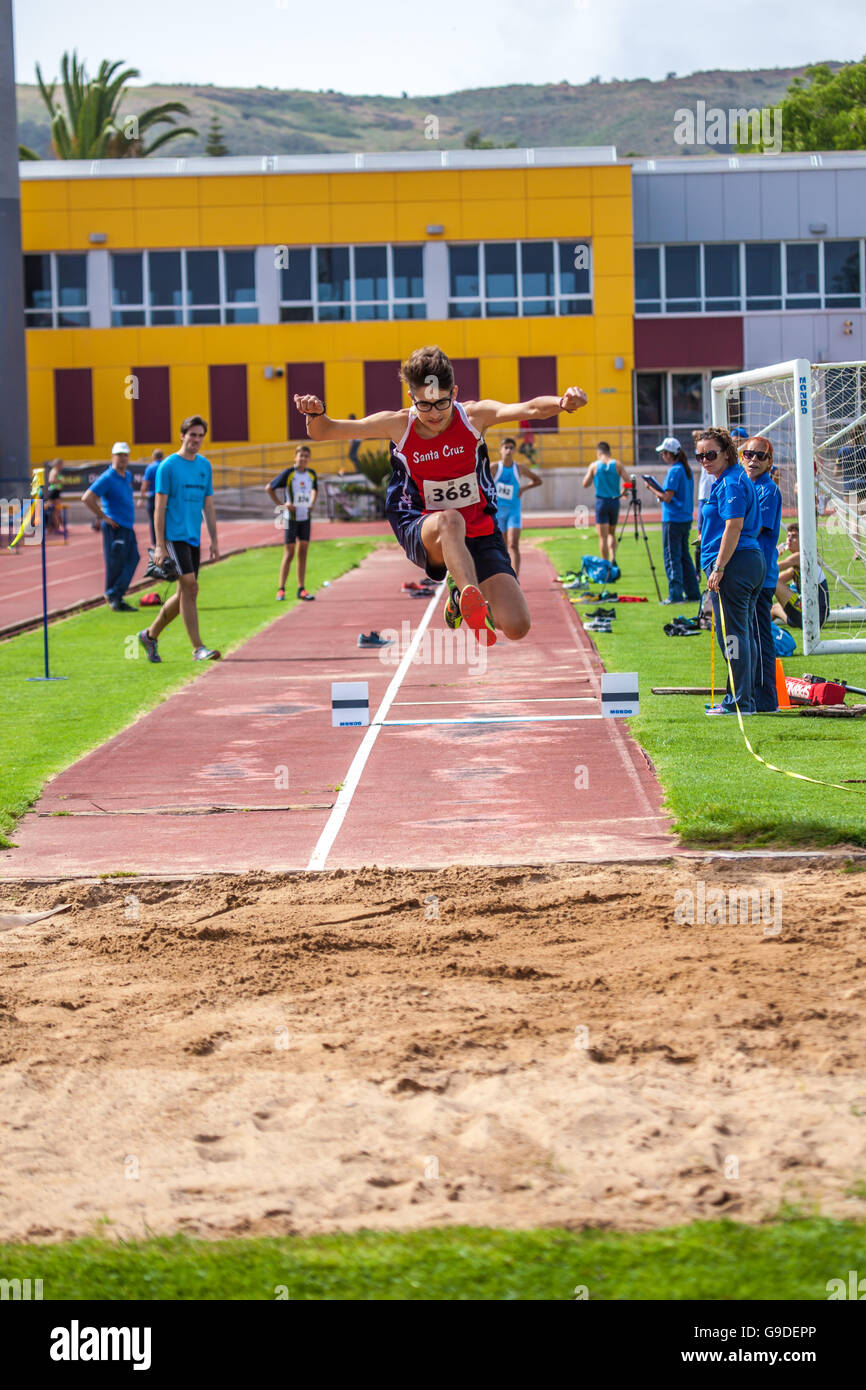 sports boy performing long jump on an athletic piste Stock Photo - Alamy
