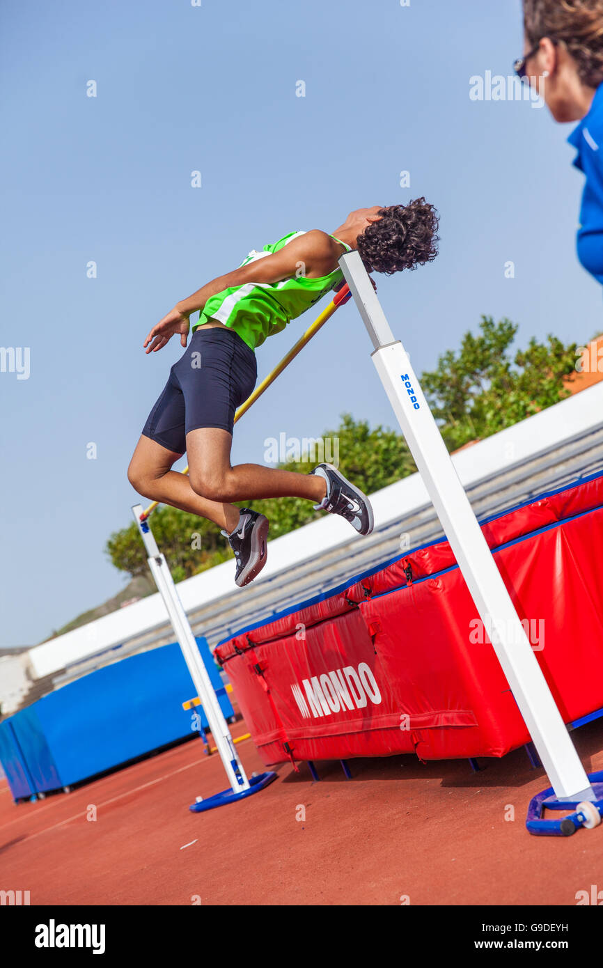 Sports boy performing the high jump on an athletic piste Stock Photo ...