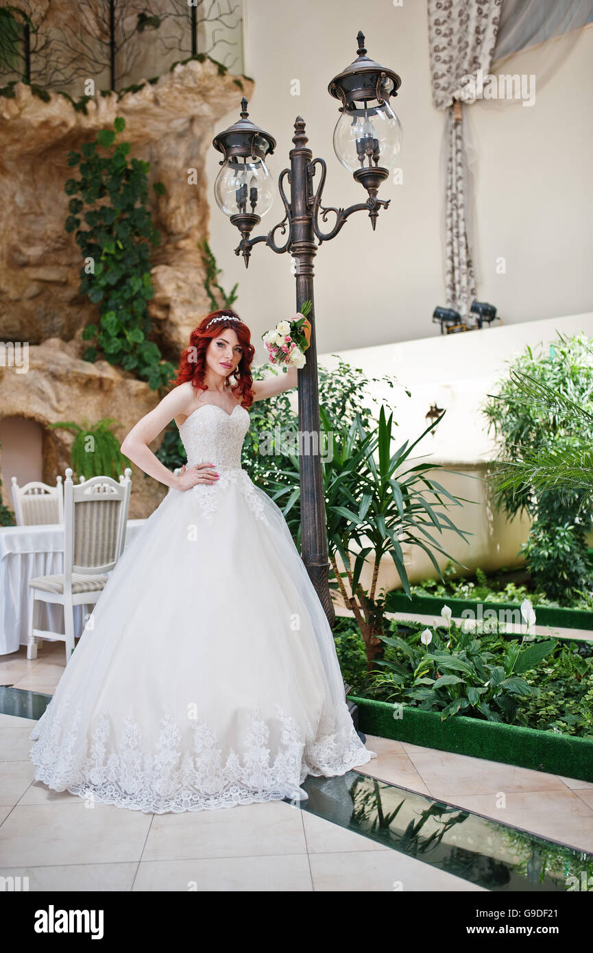 Portrait of charming red-haired bride model with wedding bouquet at ...