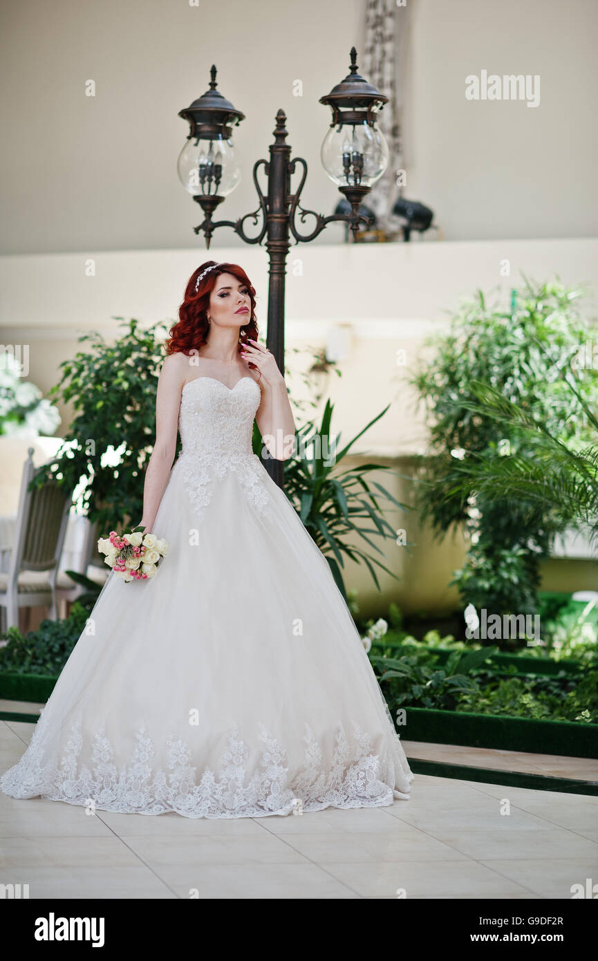 Portrait of charming red-haired bride model with wedding bouquet at ...