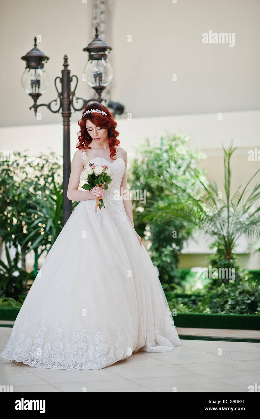 Portrait of charming red-haired bride model with wedding bouquet at ...