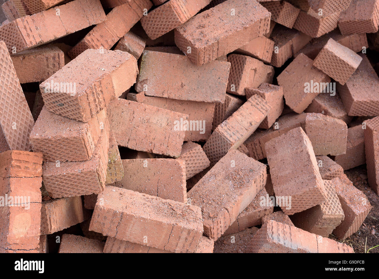 Piles of red construction bricks scattered on the ground. Copyspace ...
