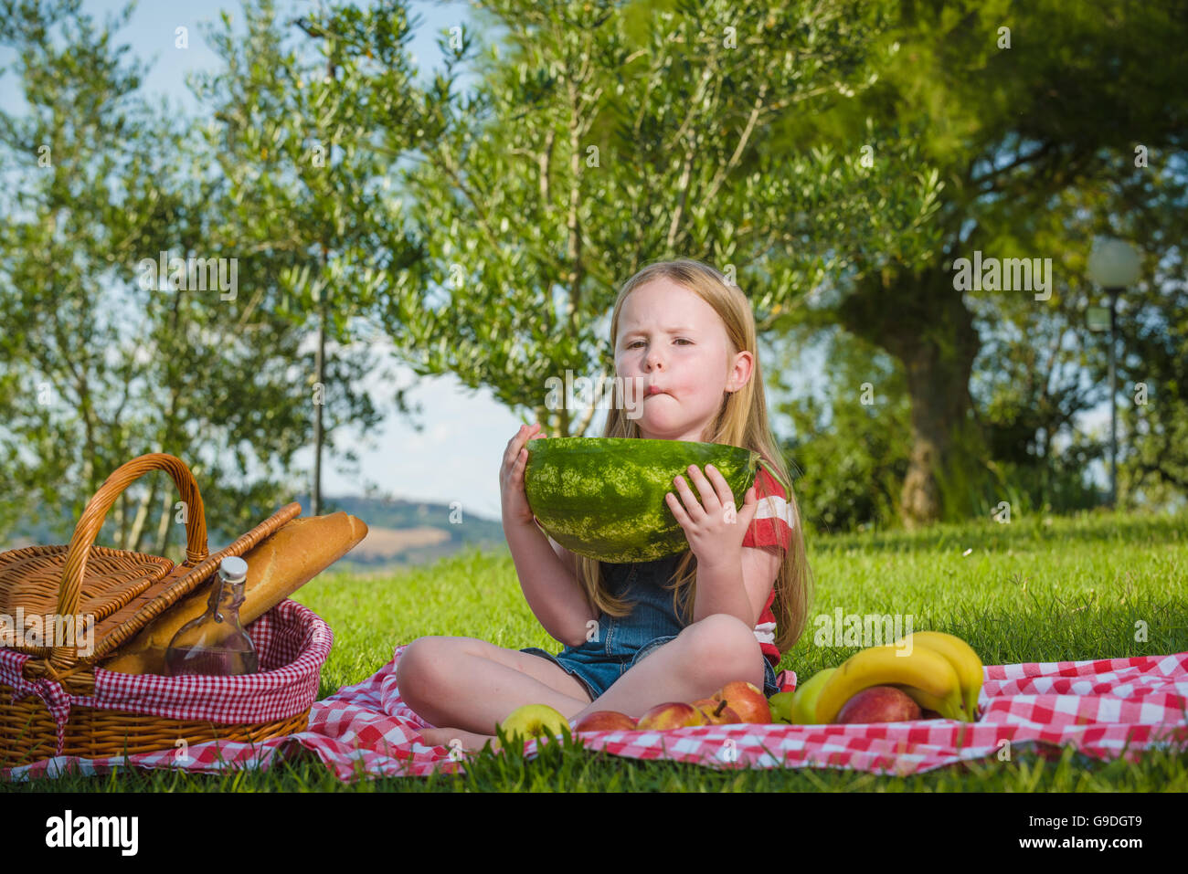 Small beautiful blond girl doing picnic in the landscape of Tuscan ...