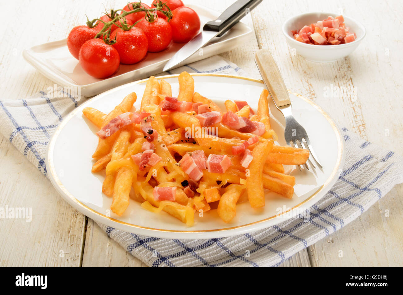 smoked bacon cubes and golden brown french fries with melted cheese on ...
