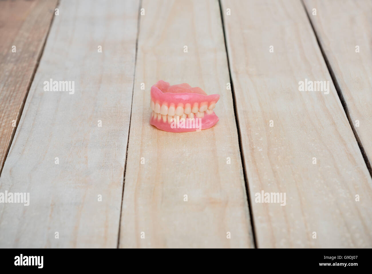 Dentures on wooden table Stock Photo - Alamy
