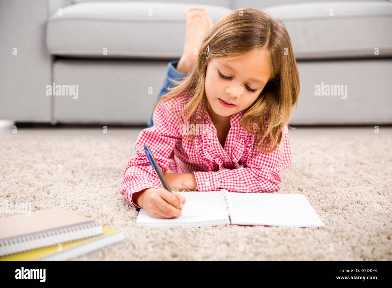 Cute little girl at home studying Stock Photo - Alamy