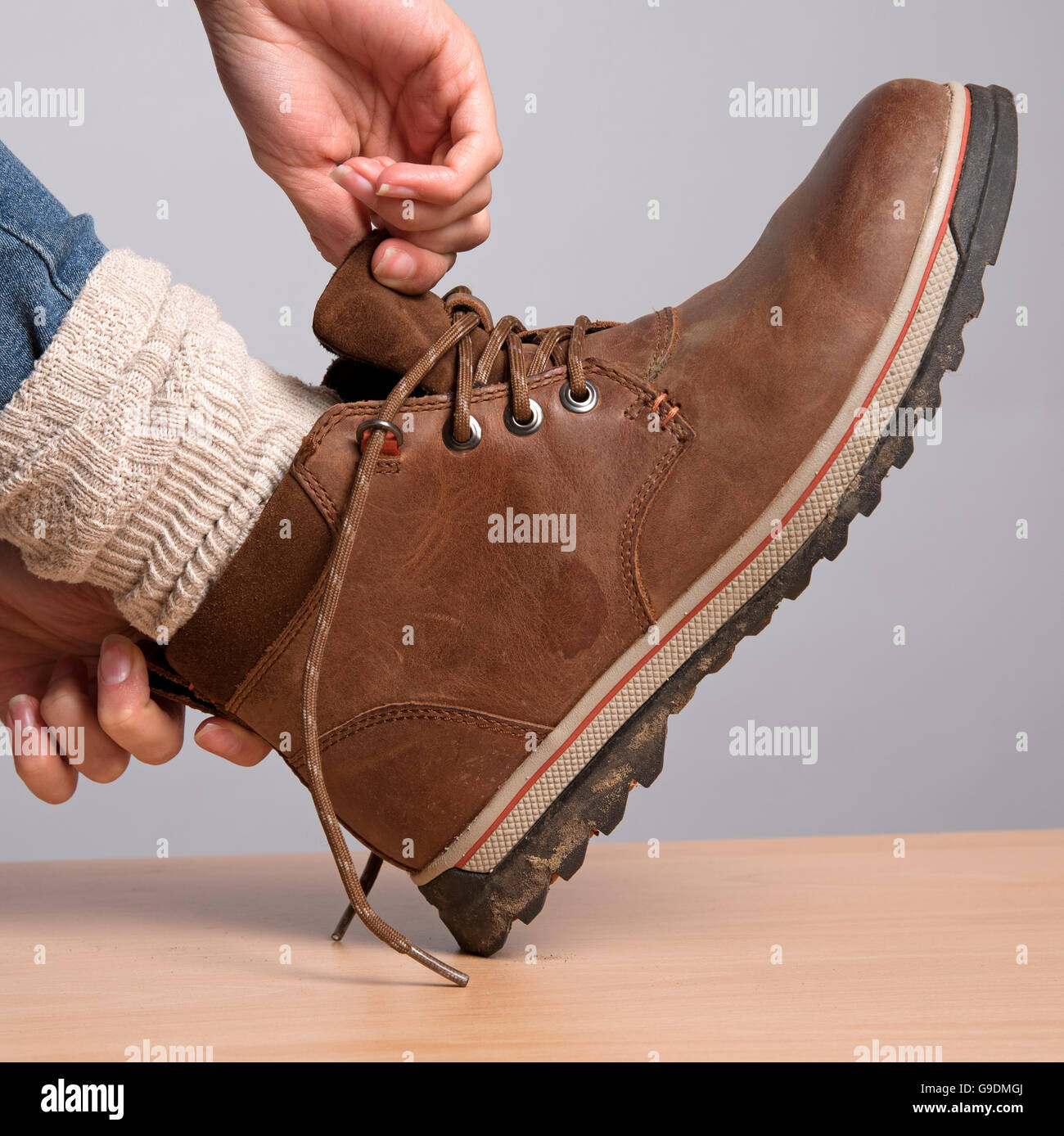 Woman's hands putting on a brown walking boot Stock Photo - Alamy