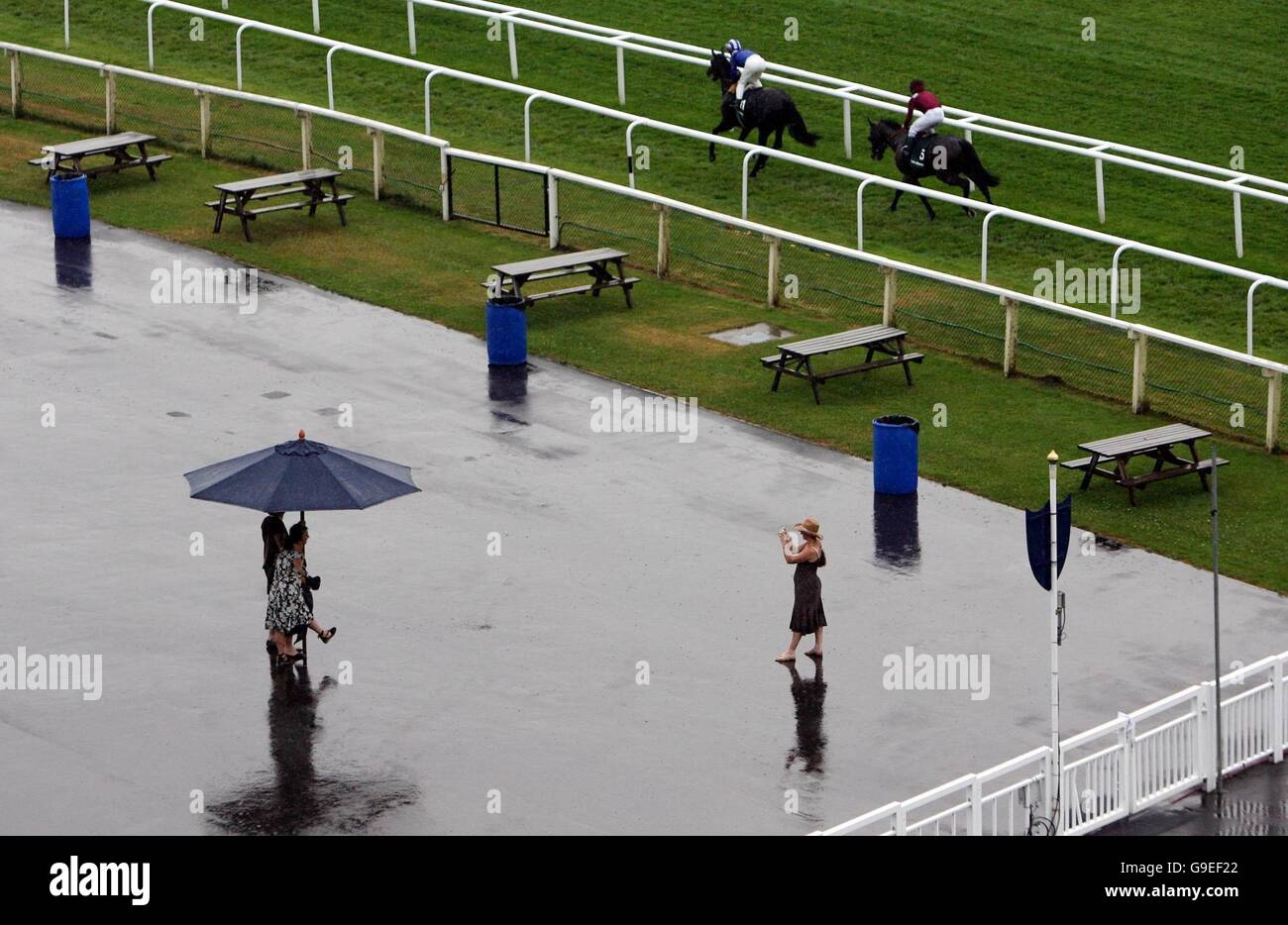 Race goers have their picture taken under an umbrella as the runners ...