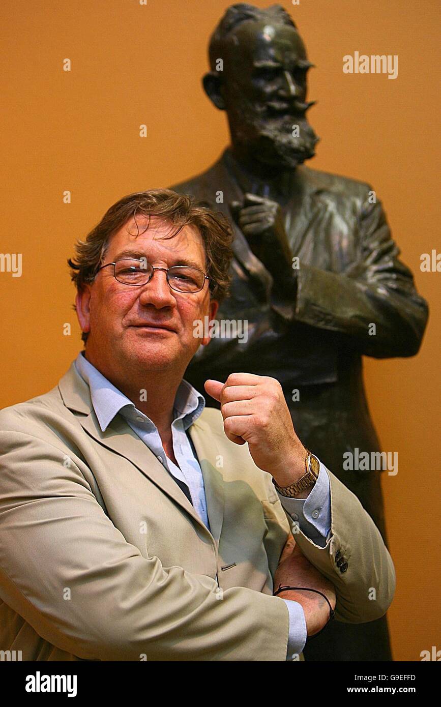 Actor Alan Stanford stands in front of a statue of Irish playwright ...