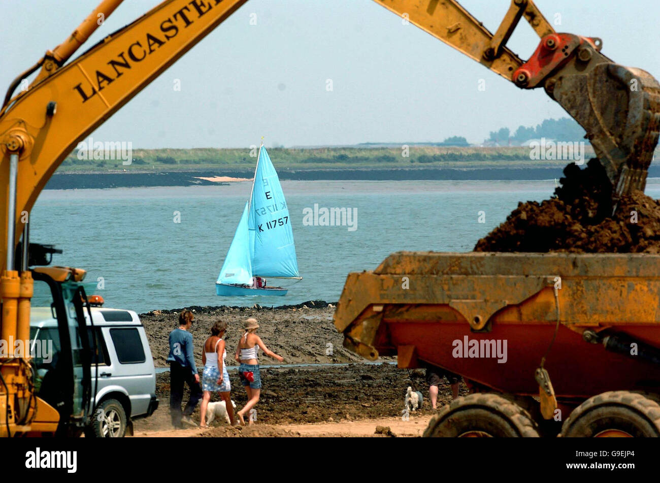 Earth movers and mechanical diggers breach the sea wall at Wallasea ...