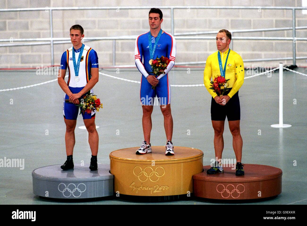 Great Britain's Jason Queally (centre) proudly stands on the podium ...