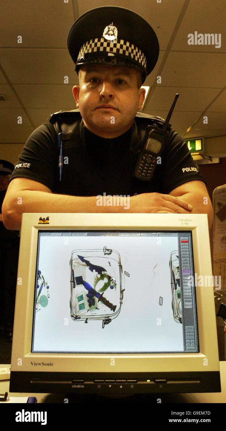 Police monitor knives passing through an x-ray machine at Glasgow ...